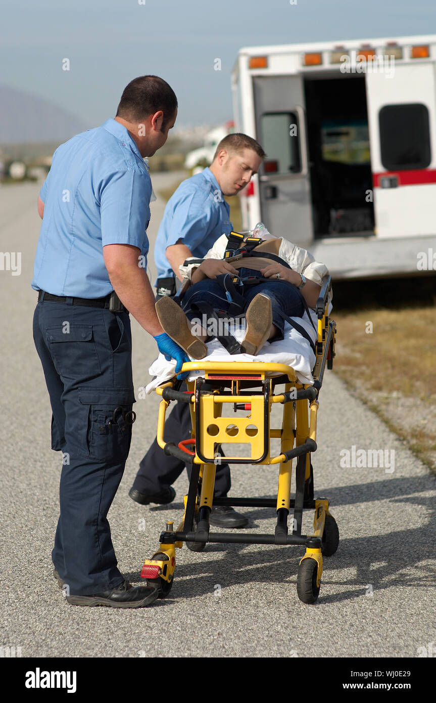 Paramedics transporting victim on stretcher Stock Photo - Alamy