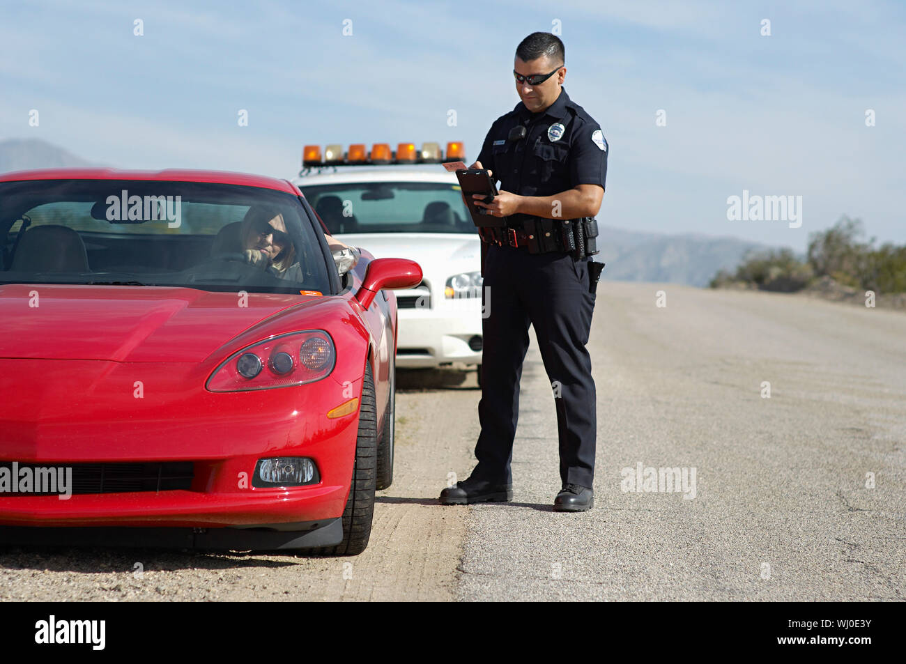 Traffic cop standing by sports car Stock Photo - Alamy