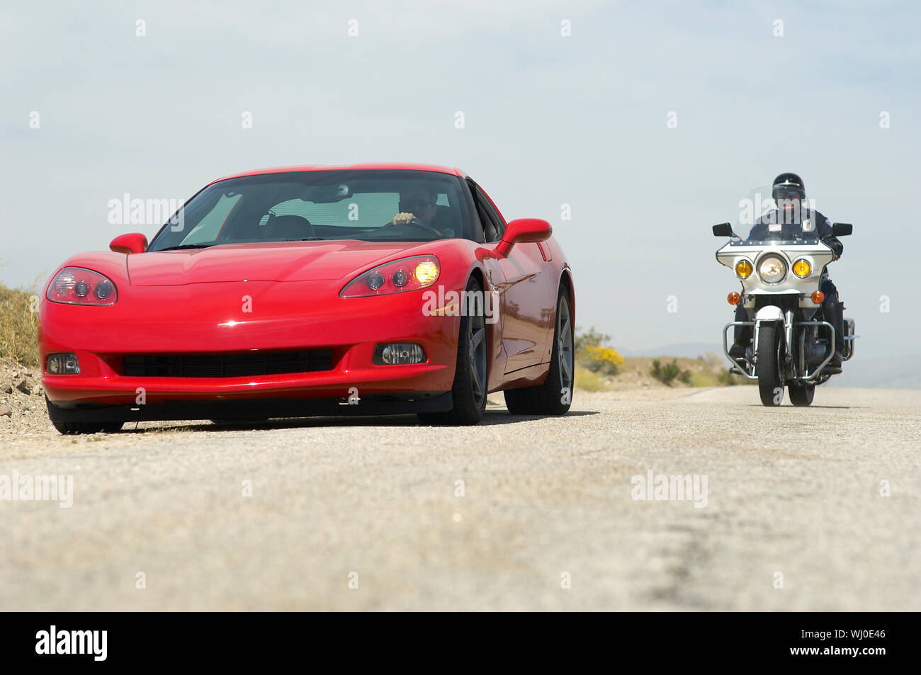 Traffic cop on motorcycle stopping sports car Stock Photo - Alamy