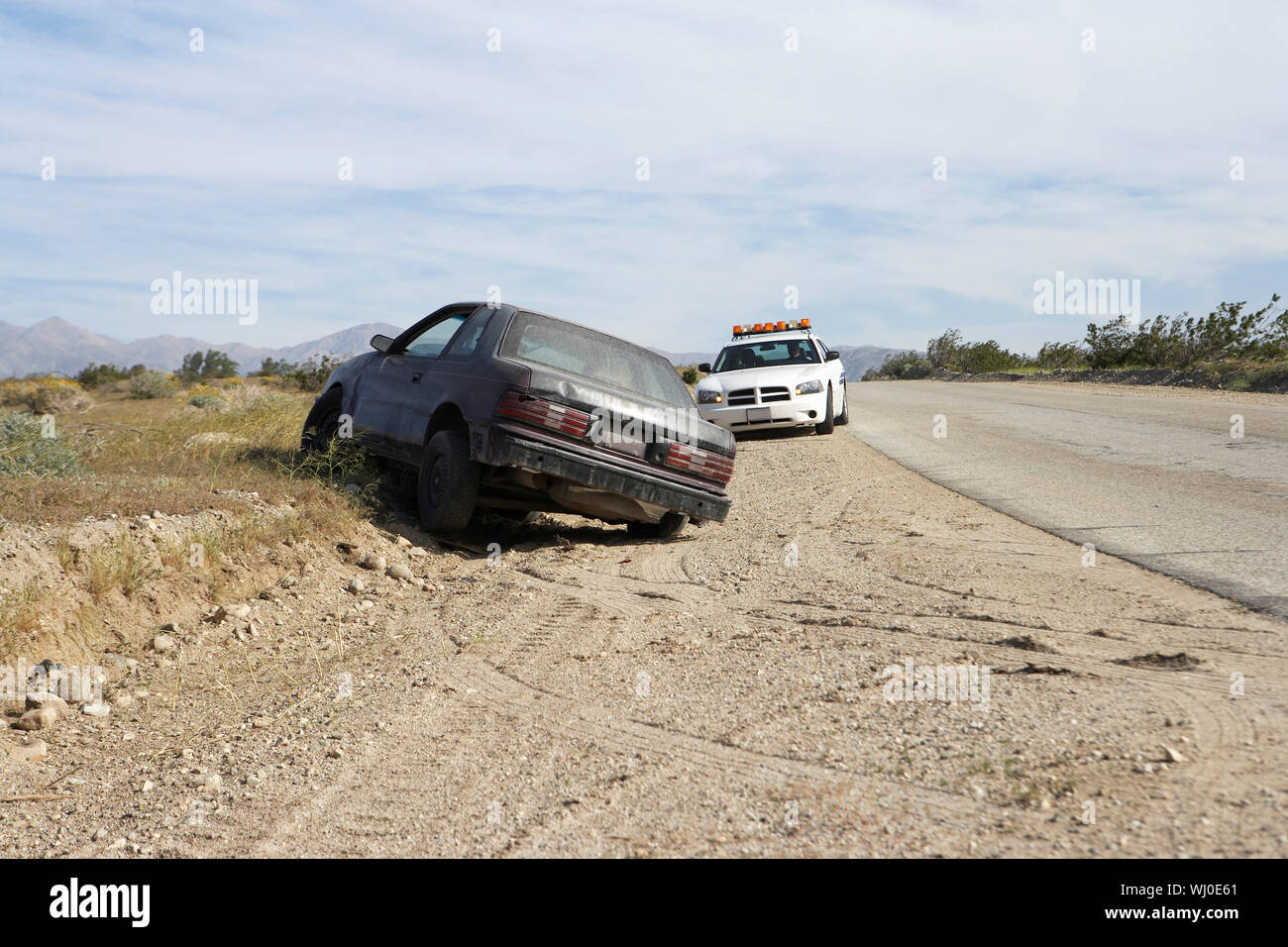 Police car near abandoned car on roadside Stock Photo - Alamy