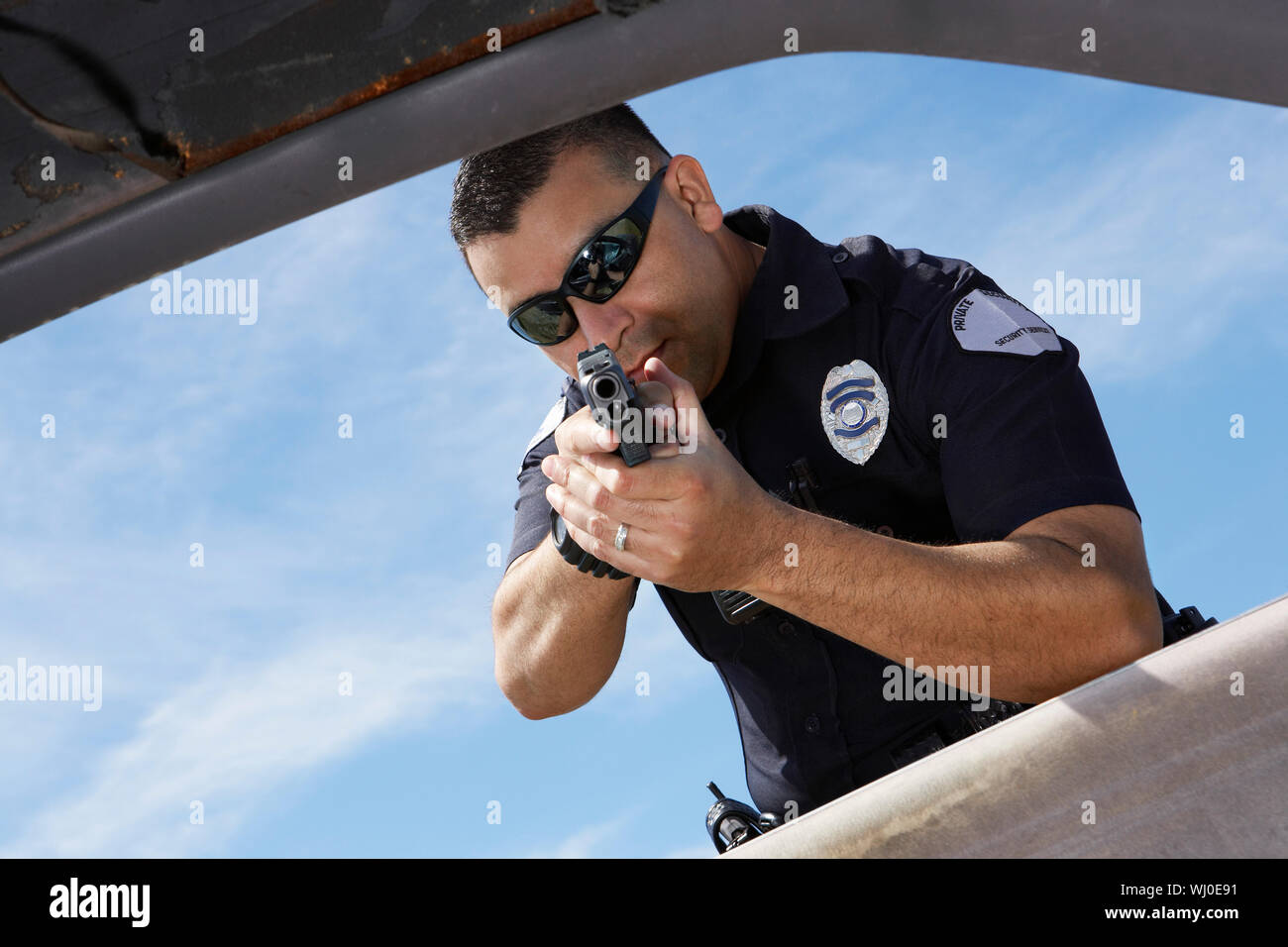 Police officer aiming gun through car window Stock Photo - Alamy