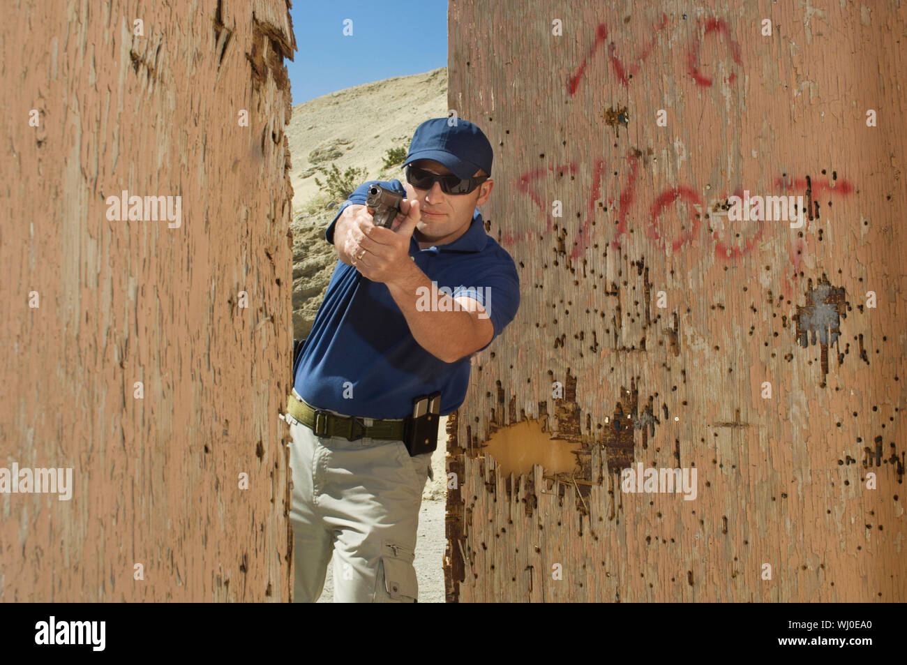 Man aiming hand gun at firing range Stock Photo - Alamy