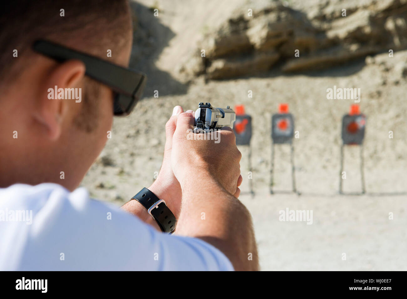 Man aiming hand gun at firing range Stock Photo - Alamy