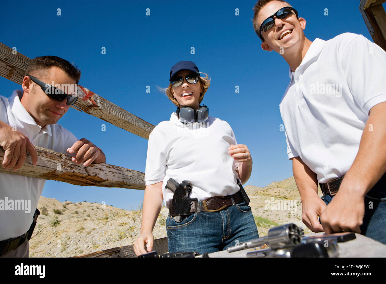 Men and woman with hand guns at firing range Stock Photo - Alamy