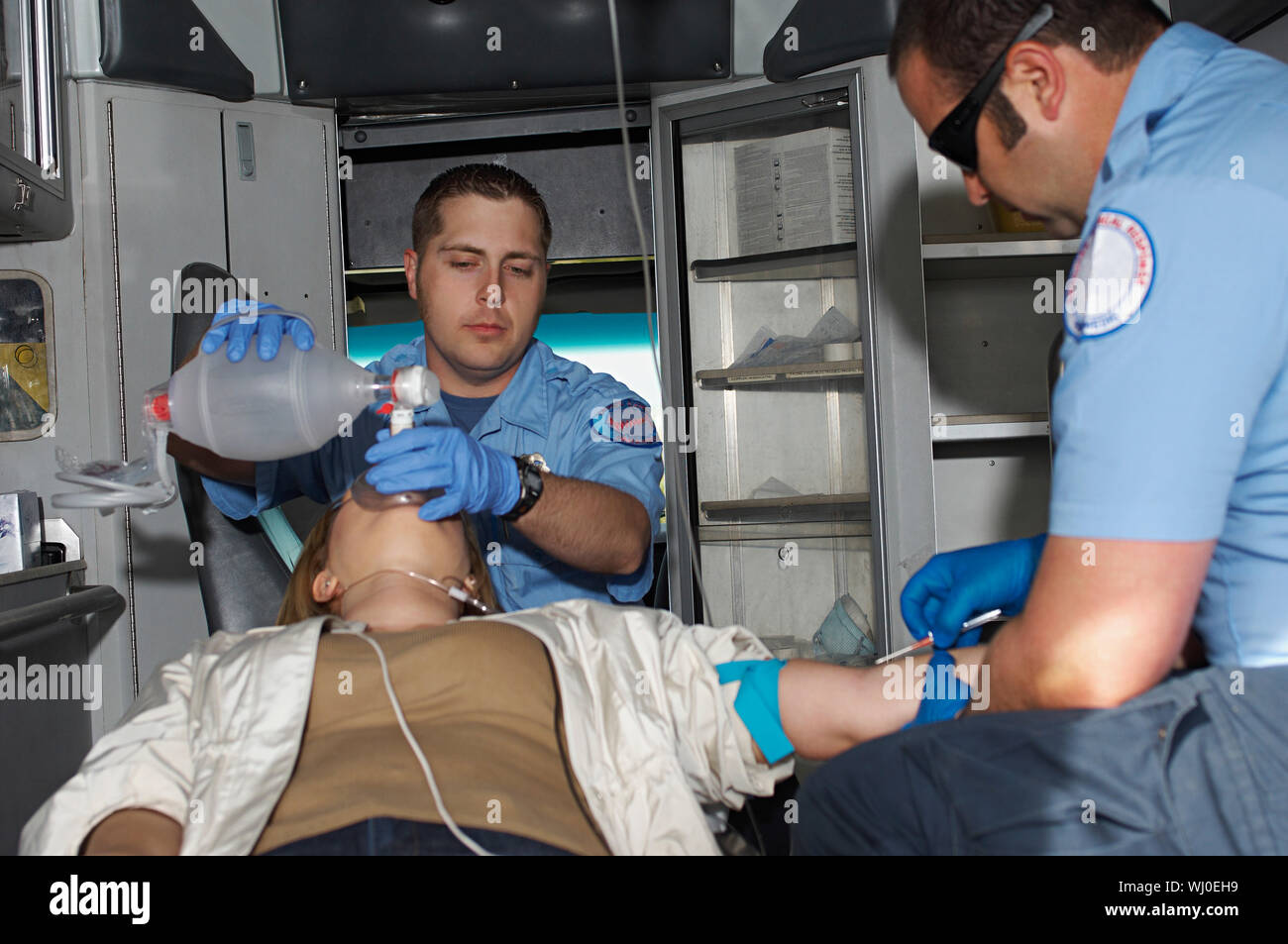 Paramedics taking care of victim in ambulance Stock Photo - Alamy