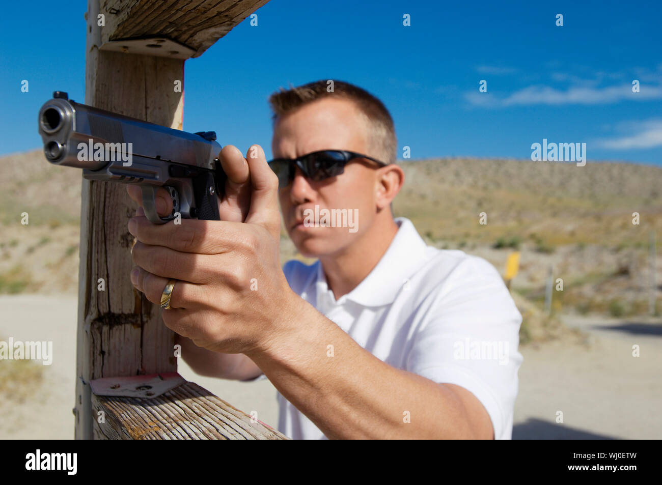 Man aiming hand gun at firing range Stock Photo - Alamy