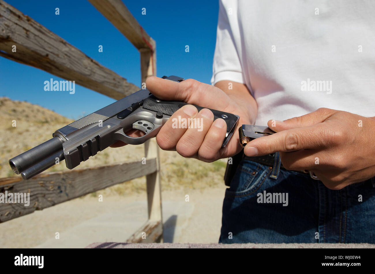 Man loading magazine into gun at firing range, close-up Stock Photo - Alamy