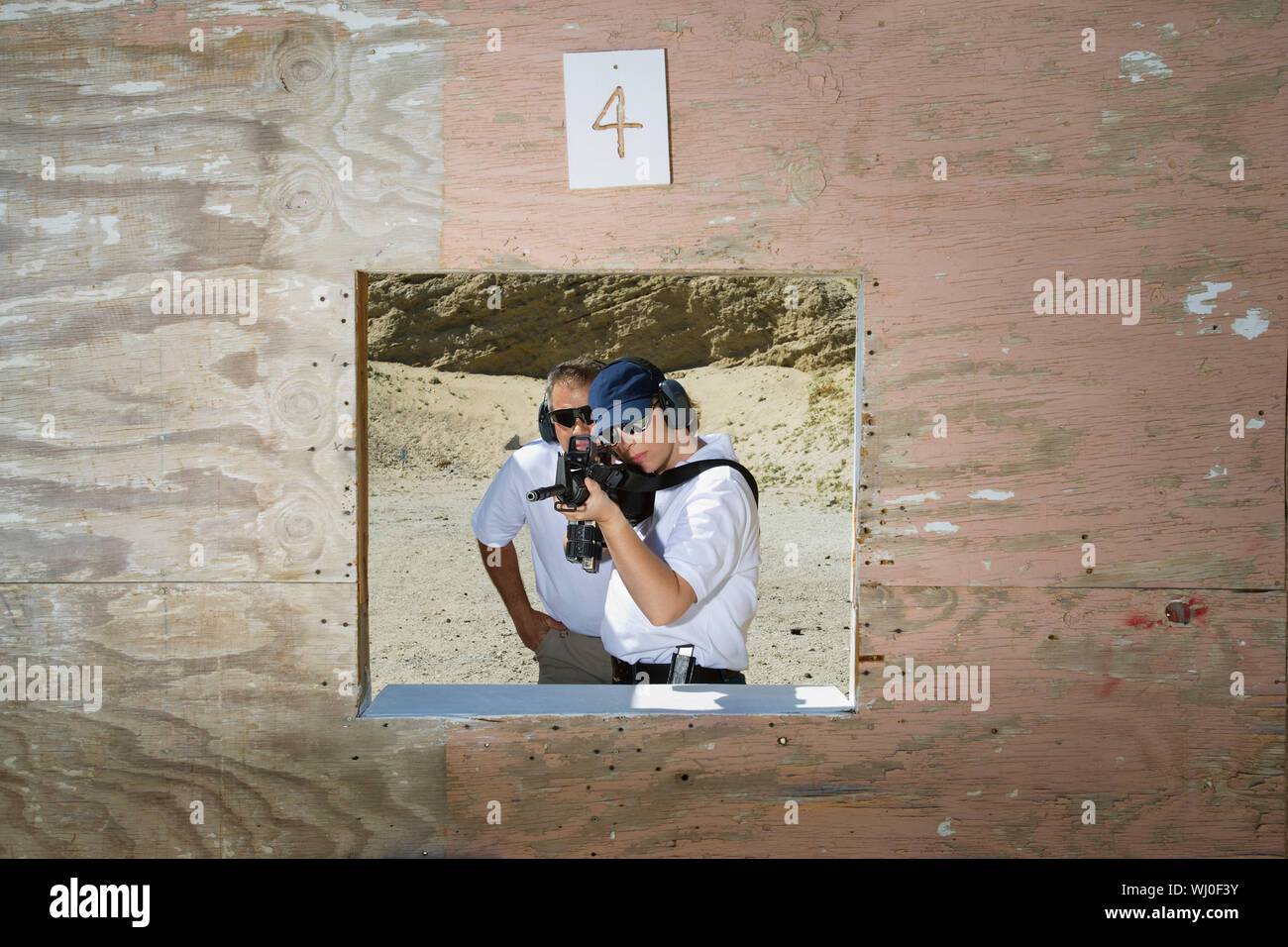 Instructor assisting woman aiming machine gun at firing range Stock ...