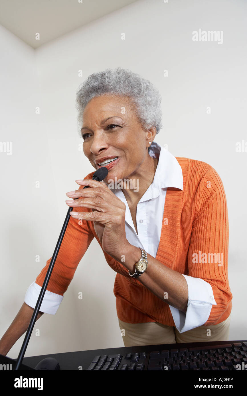 Female teacher using microphone indoors Stock Photo - Alamy