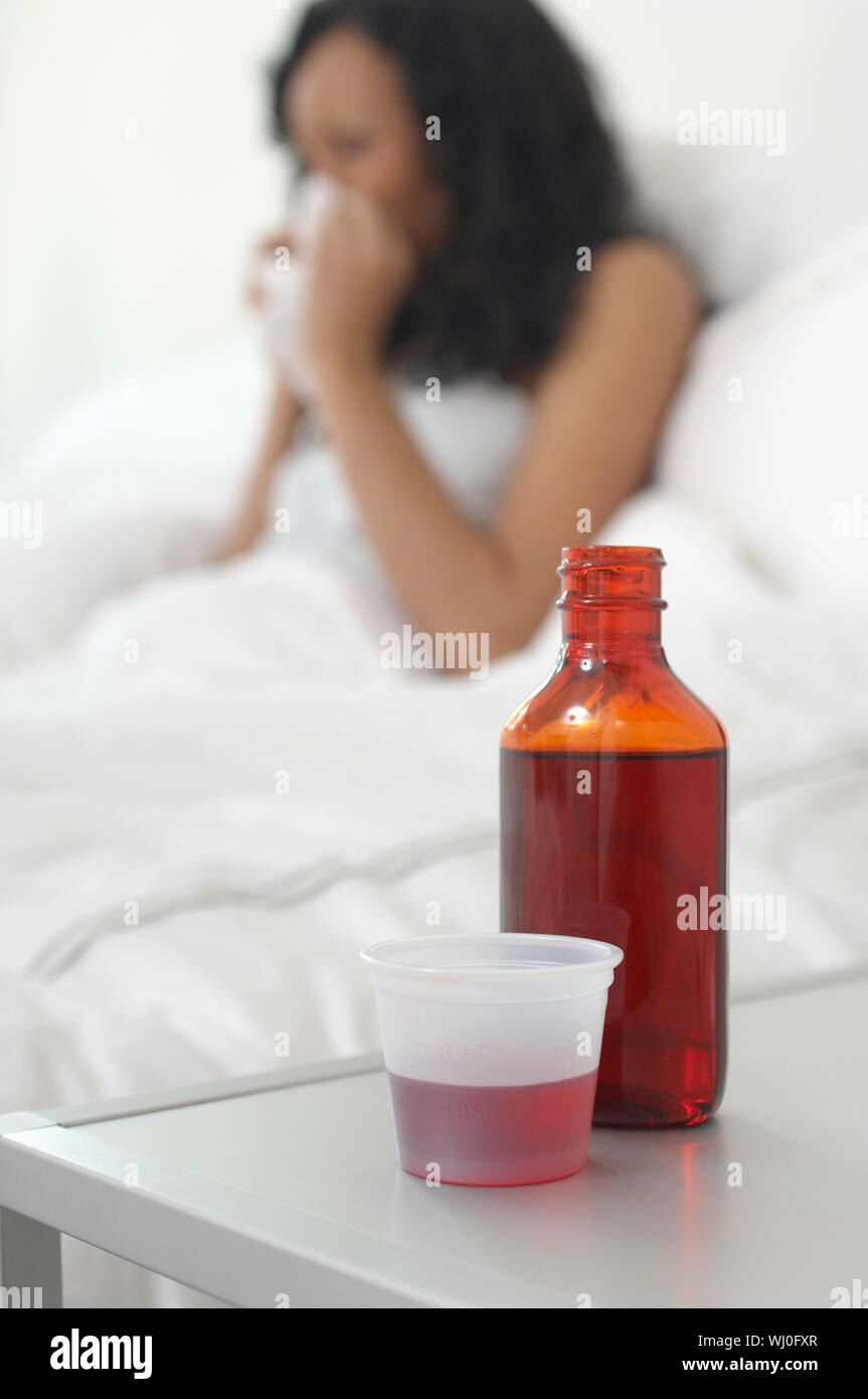 Medicine on bedside table beside woman in bed Stock Photo - Alamy