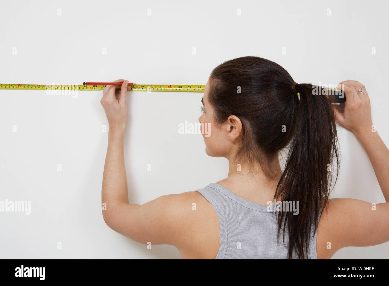 Woman measuring wall Stock Photo - Alamy
