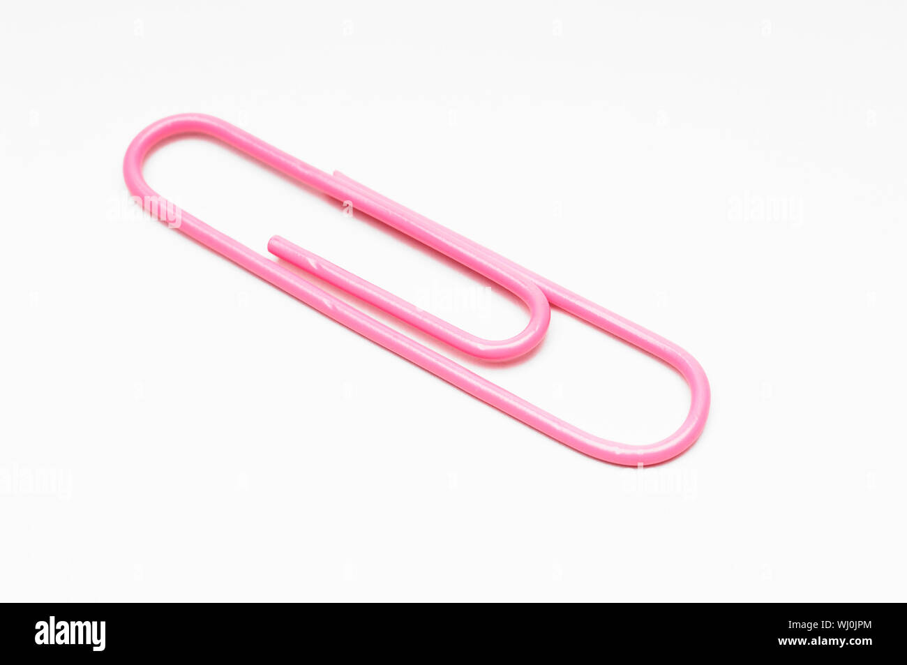 Pink paper clip on white background Stock Photo - Alamy