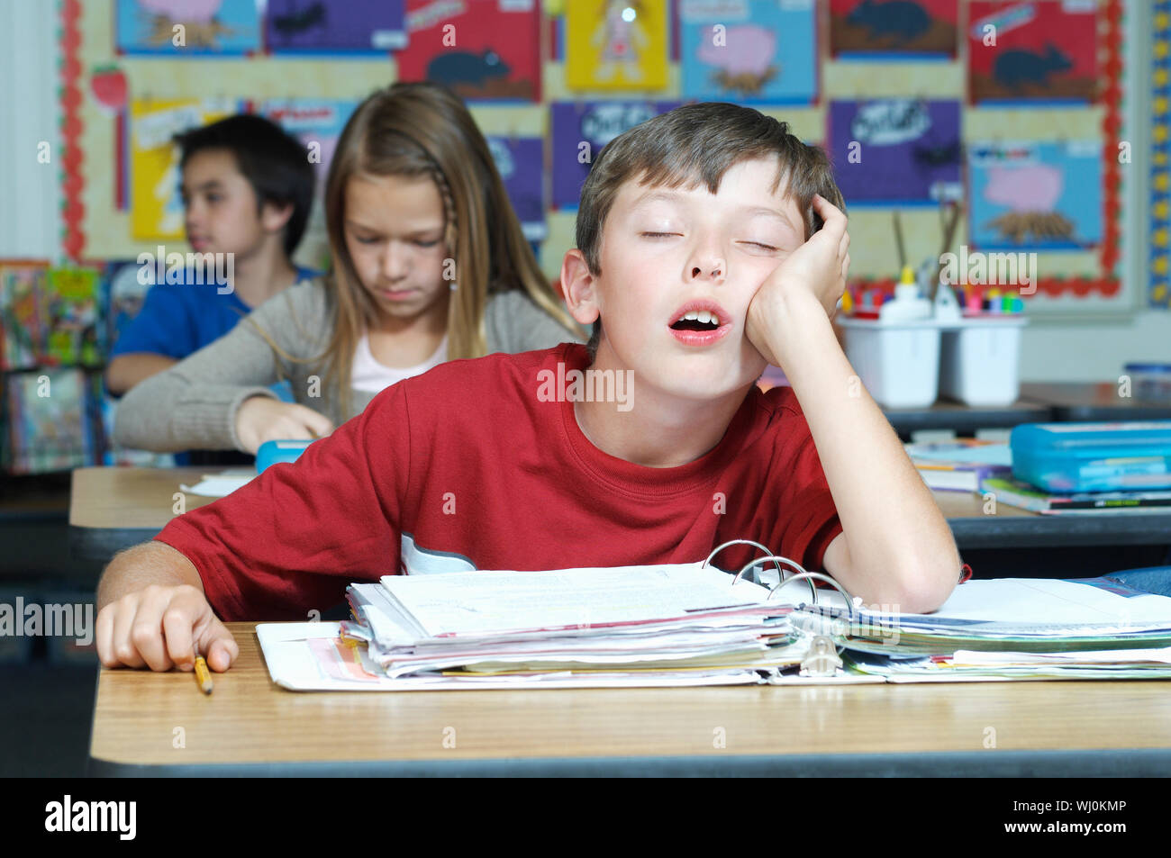 Three pupils in classroom, one of them sleeping Stock Photo - Alamy