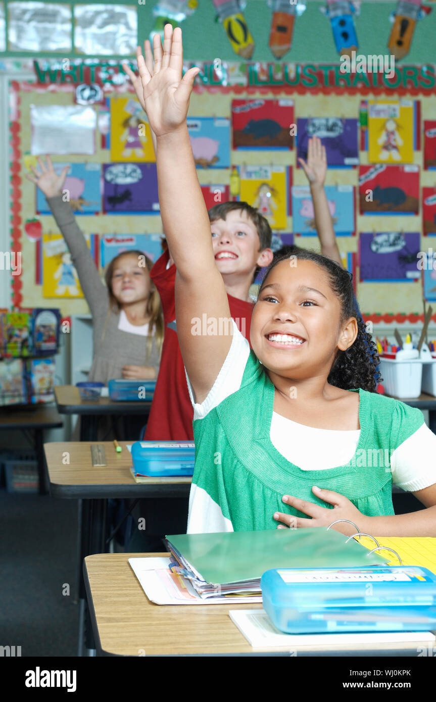 Three pupils with raised hands Stock Photo - Alamy