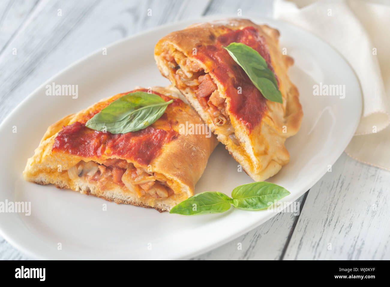Homemade calzone stuffed with pancetta and mushrooms: cross section ...