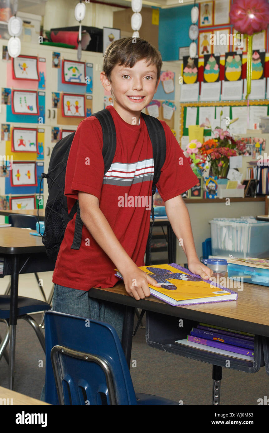 School boy standing in classroom Stock Photo - Alamy