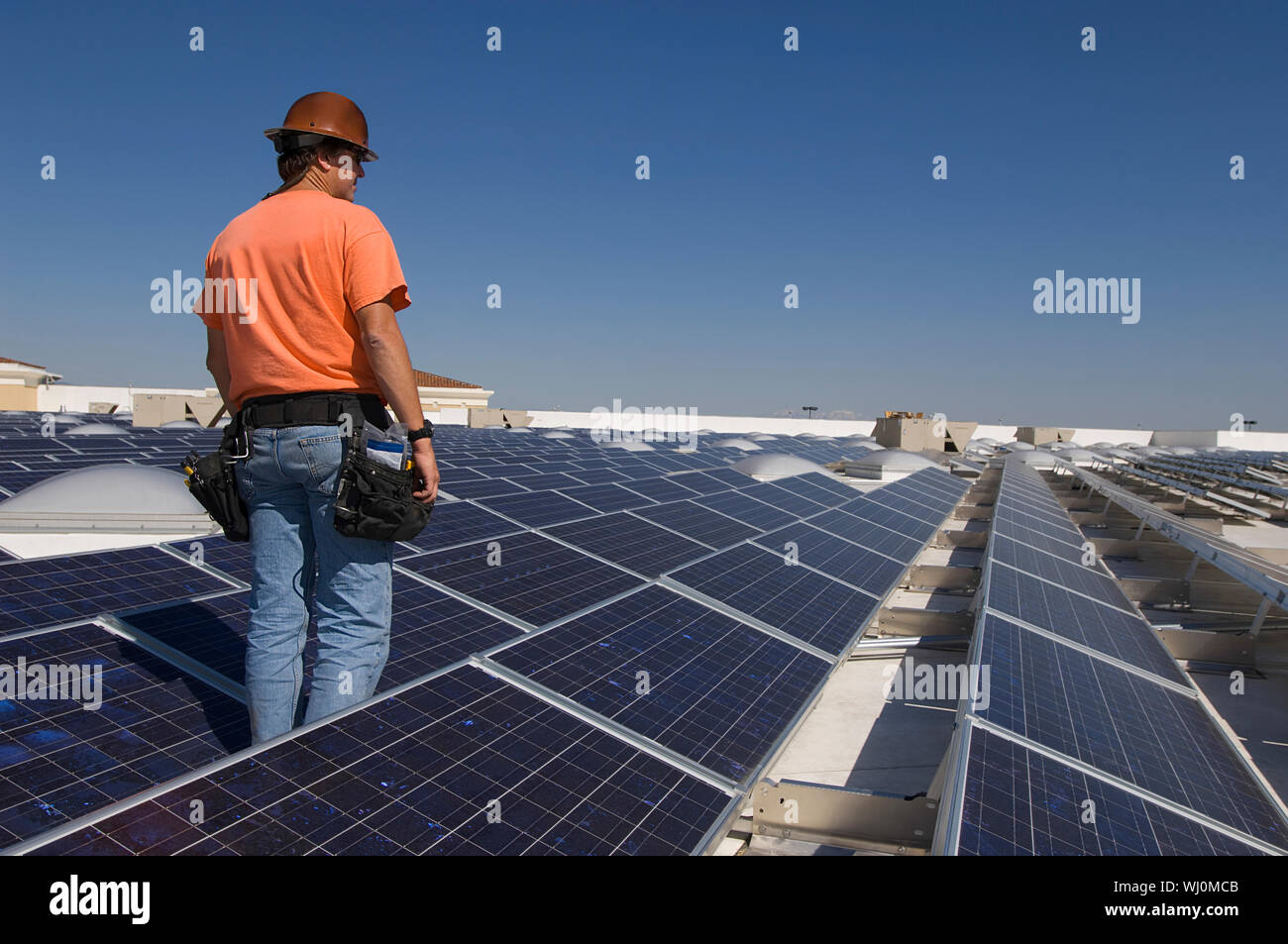 Electrical engineer among solar panels at solar power plant Stock Photo ...