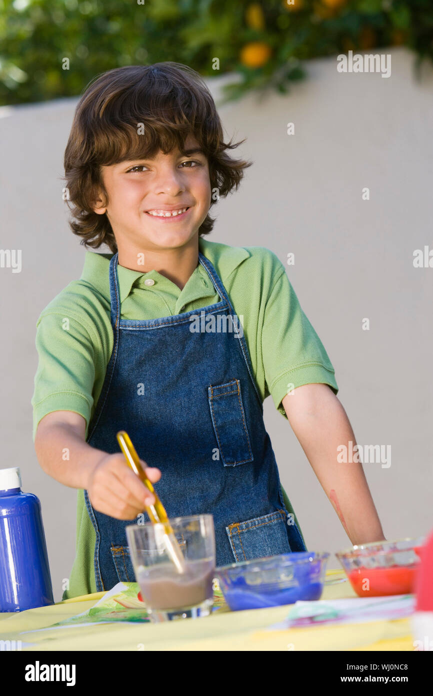 Portrait of a happy boy paining in art class Stock Photo - Alamy