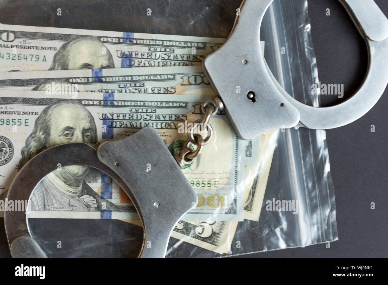 Currency in a plastic package and handcuffs. Physical evidence pack ...