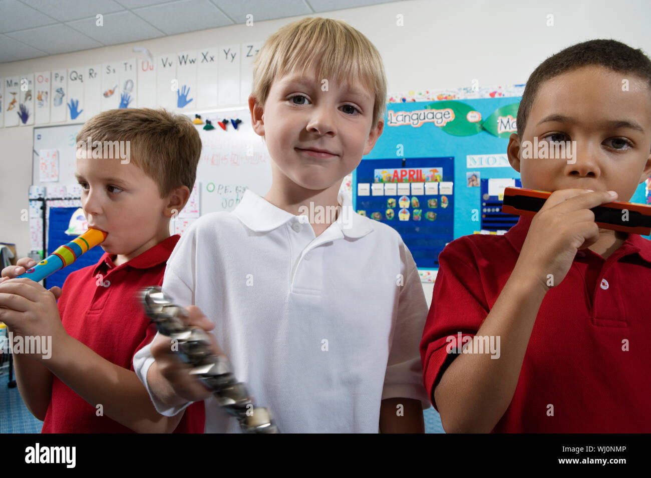 Portrait of a little boys playing musical instrument in classroom Stock ...