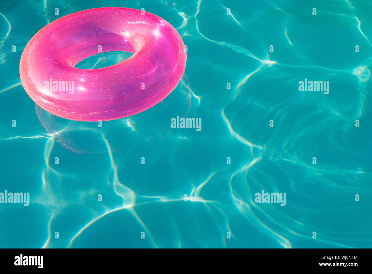 Pink Float Tube Floating in Swimming Pool Stock Photo - Alamy