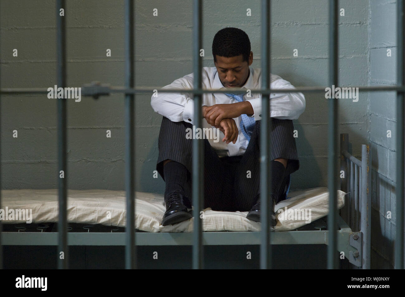 Prisoner sitting in his prison cell Stock Photo - Alamy