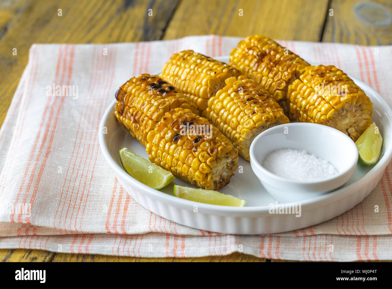 Grilled corn with sea salt and lime wedges Stock Photo - Alamy