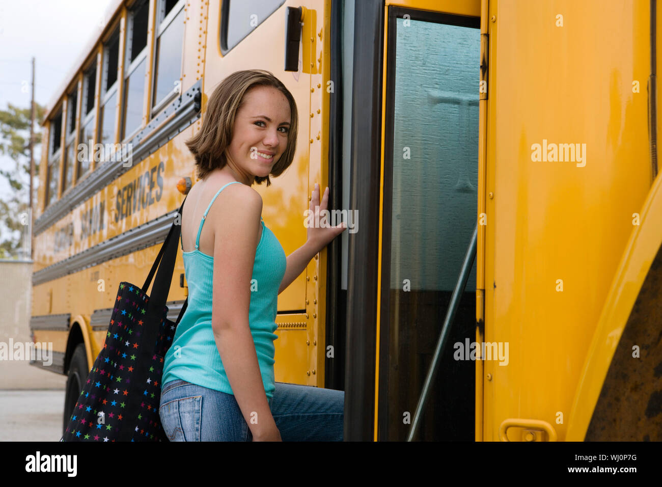 Portrait of young female student boarding school bus Stock Photo - Alamy