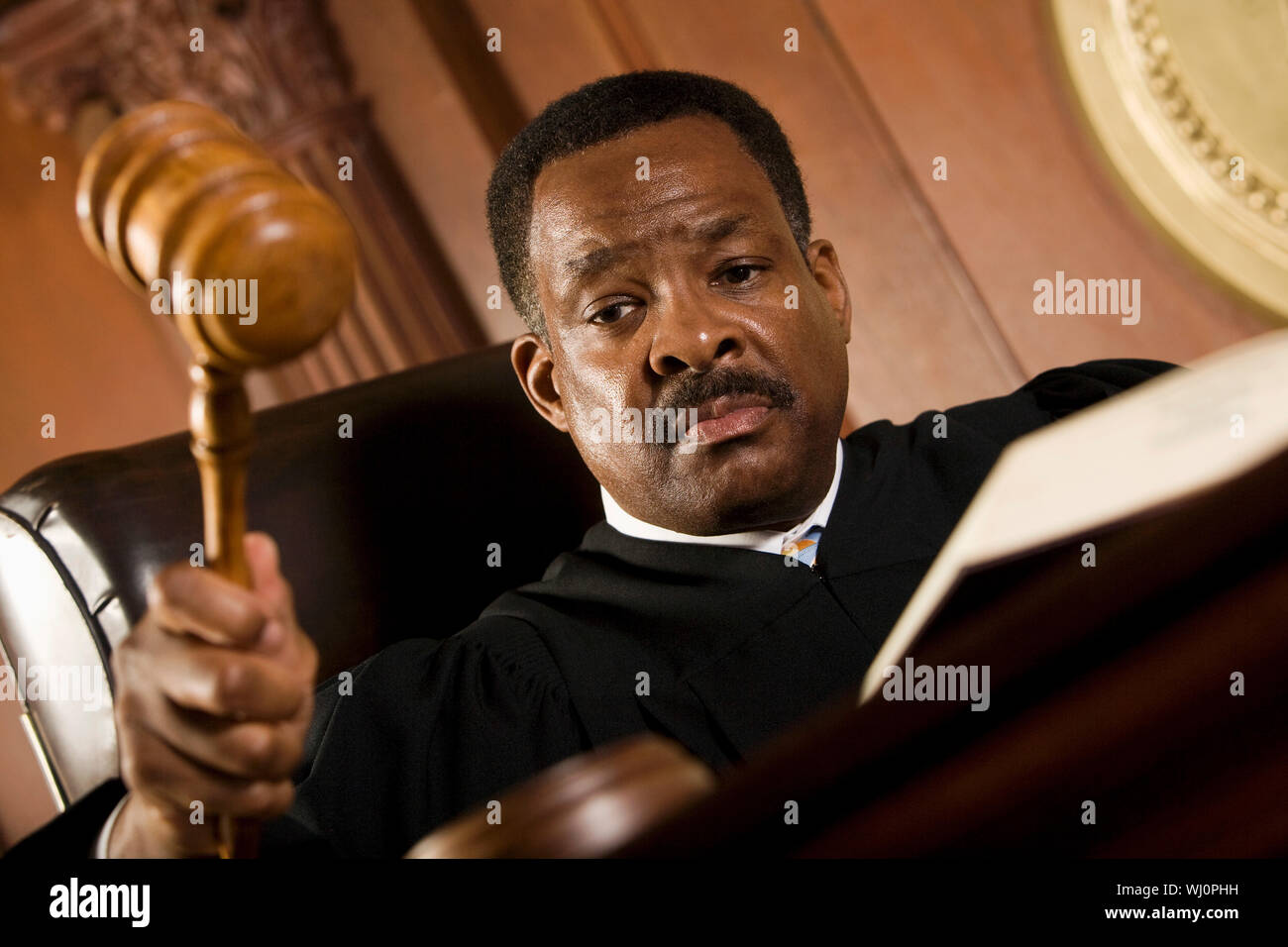 Middle-aged judge holding gavel Stock Photo - Alamy