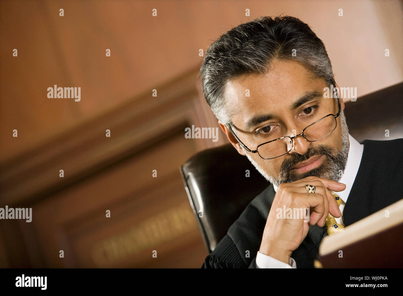 Middle-aged judge reading in a courtroom Stock Photo - Alamy