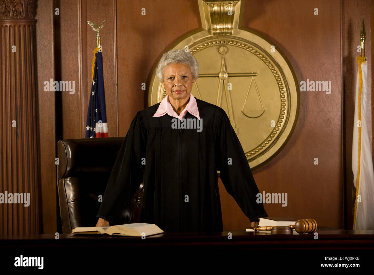 Portrait of confident senior female judge standing in court room Stock ...