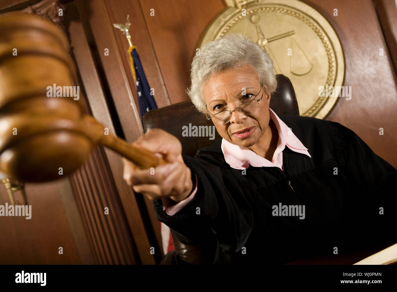 Female judge holding hammer in court Stock Photo - Alamy