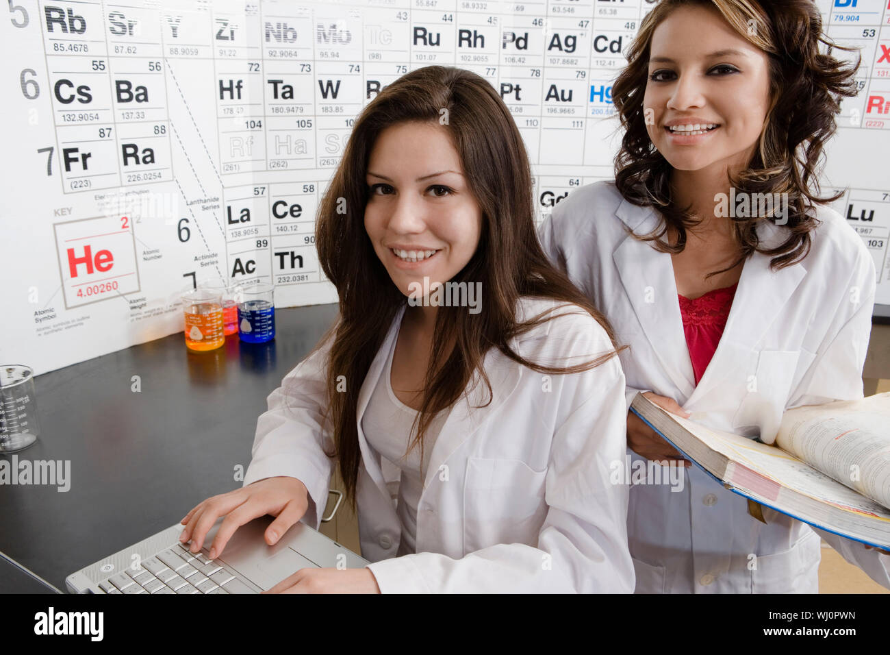 Portrait of classmates in chemistry lab with laptop and book Stock ...