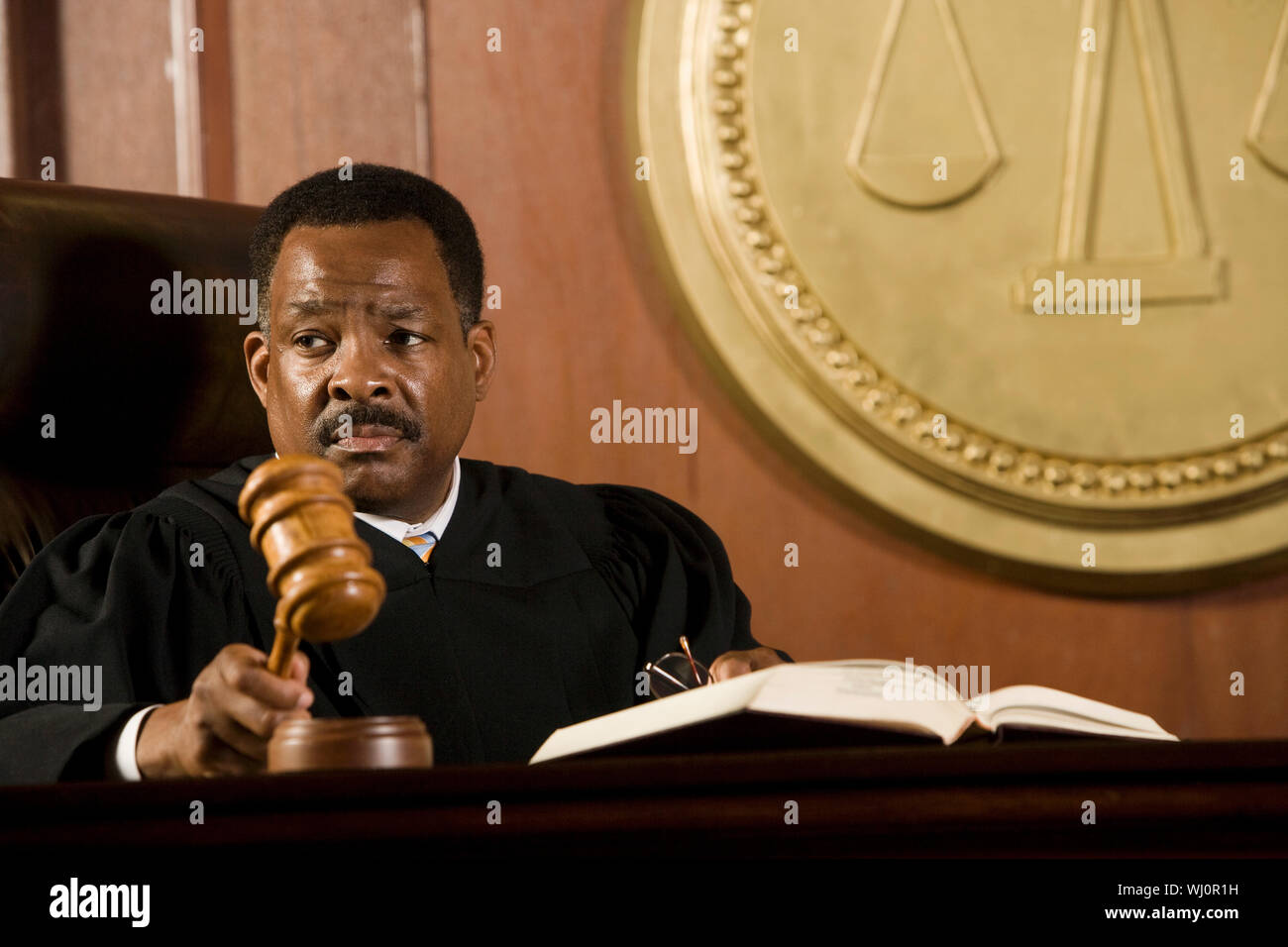 Middle-aged judge holding gavel Stock Photo - Alamy