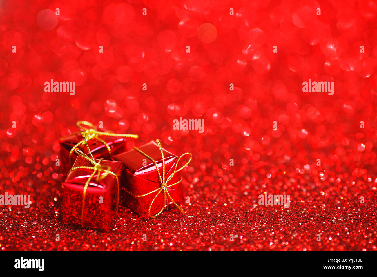 Red Christmas gift boxes on shiny glitter background Stock Photo - Alamy