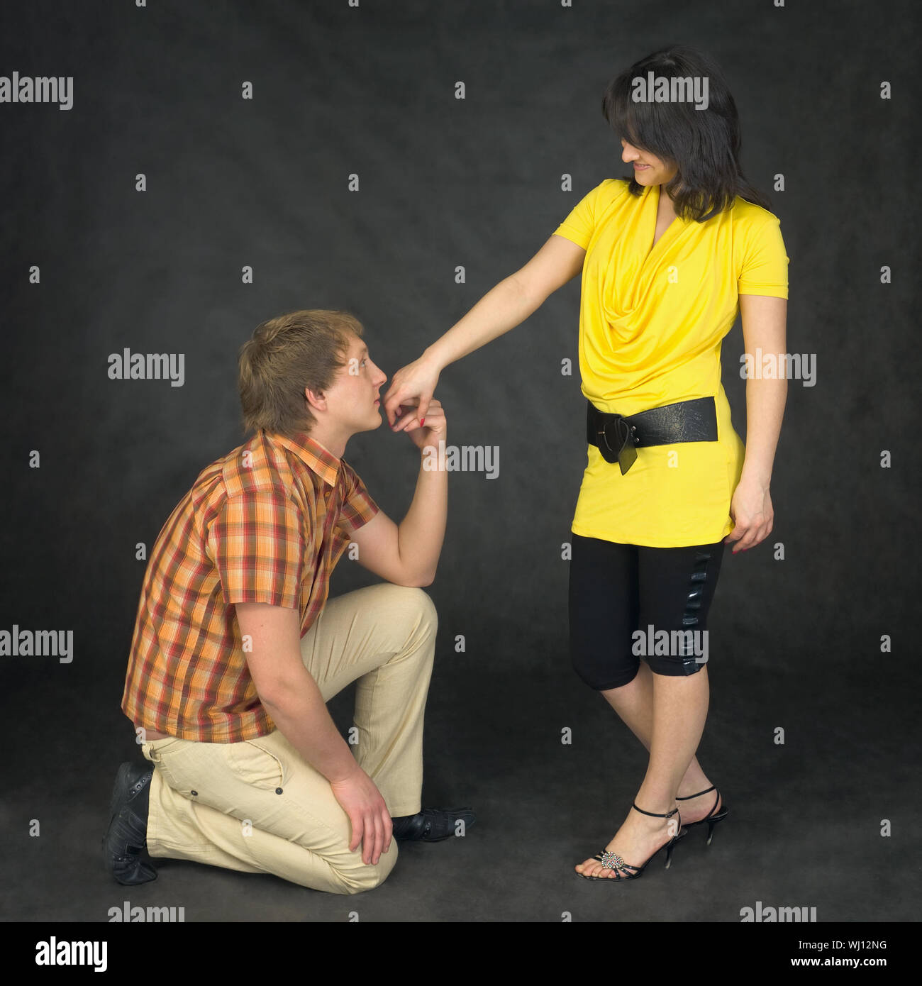 Man kisses a hand to the woman kneeling Stock Photo - Alamy