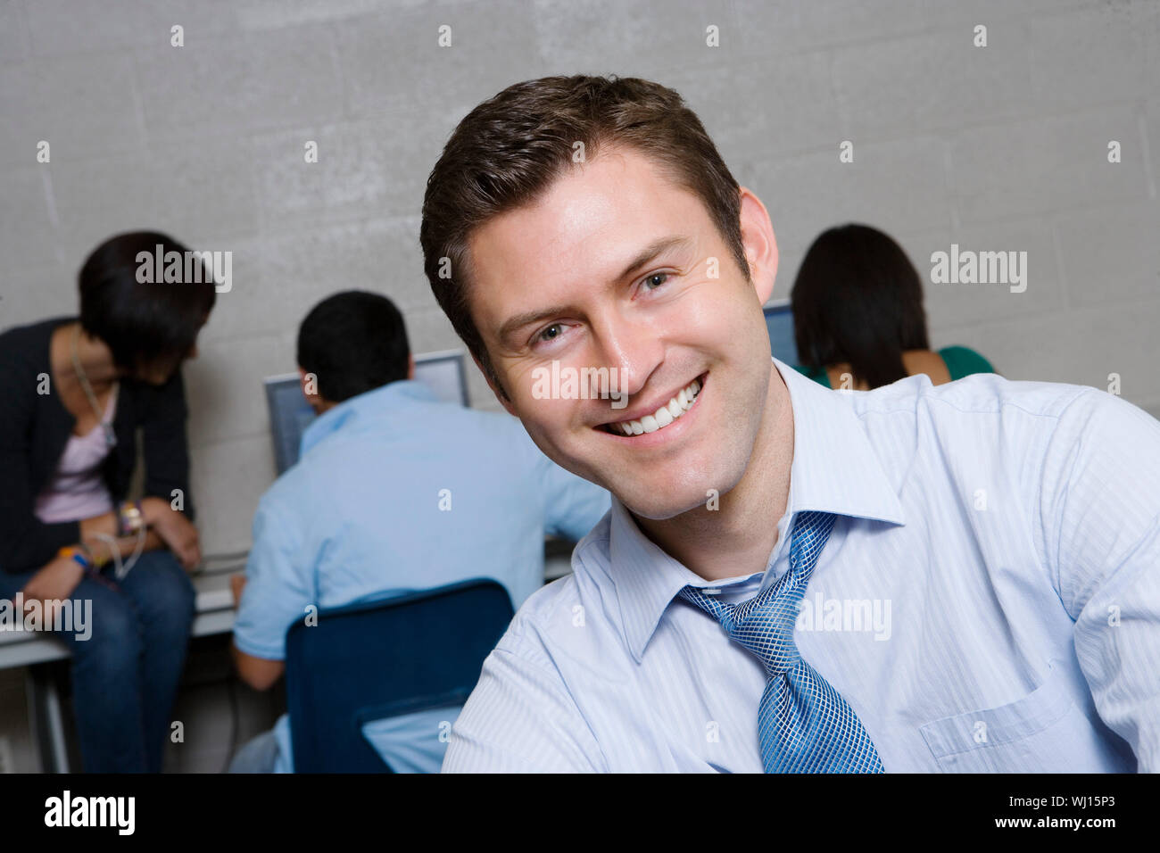 Portrait of a happy professor with students in the background Stock ...