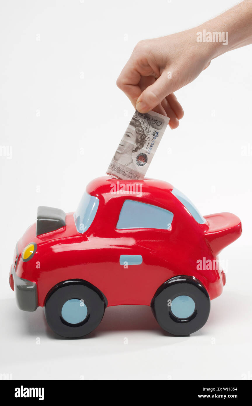 Hand putting banknote into money box Stock Photo - Alamy