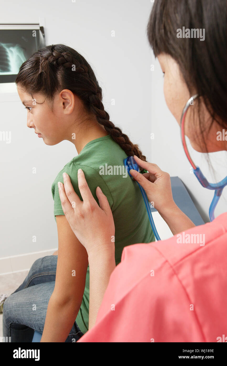 Doctor examining girl using stethoscope in hospital Stock Photo - Alamy