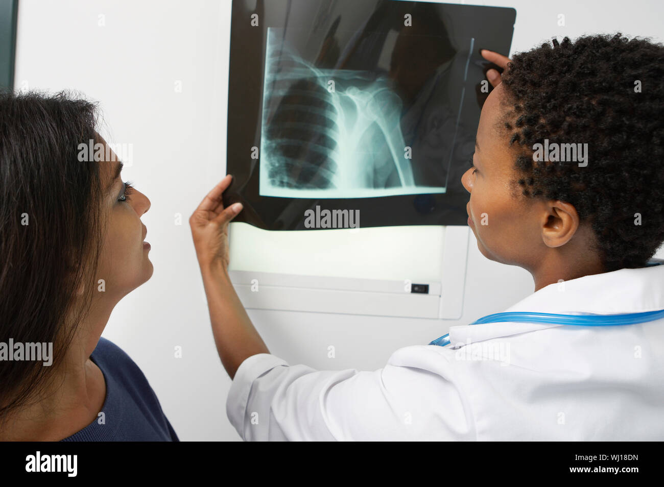 Patient and female doctor examining x-ray Stock Photo - Alamy