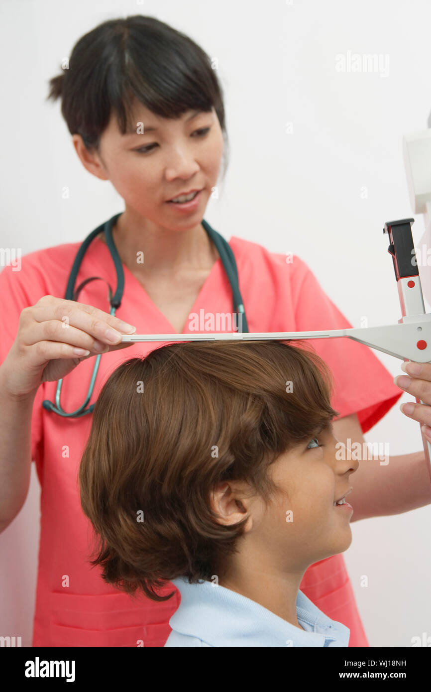 Female doctor measuring boy's height,close-up Stock Photo - Alamy