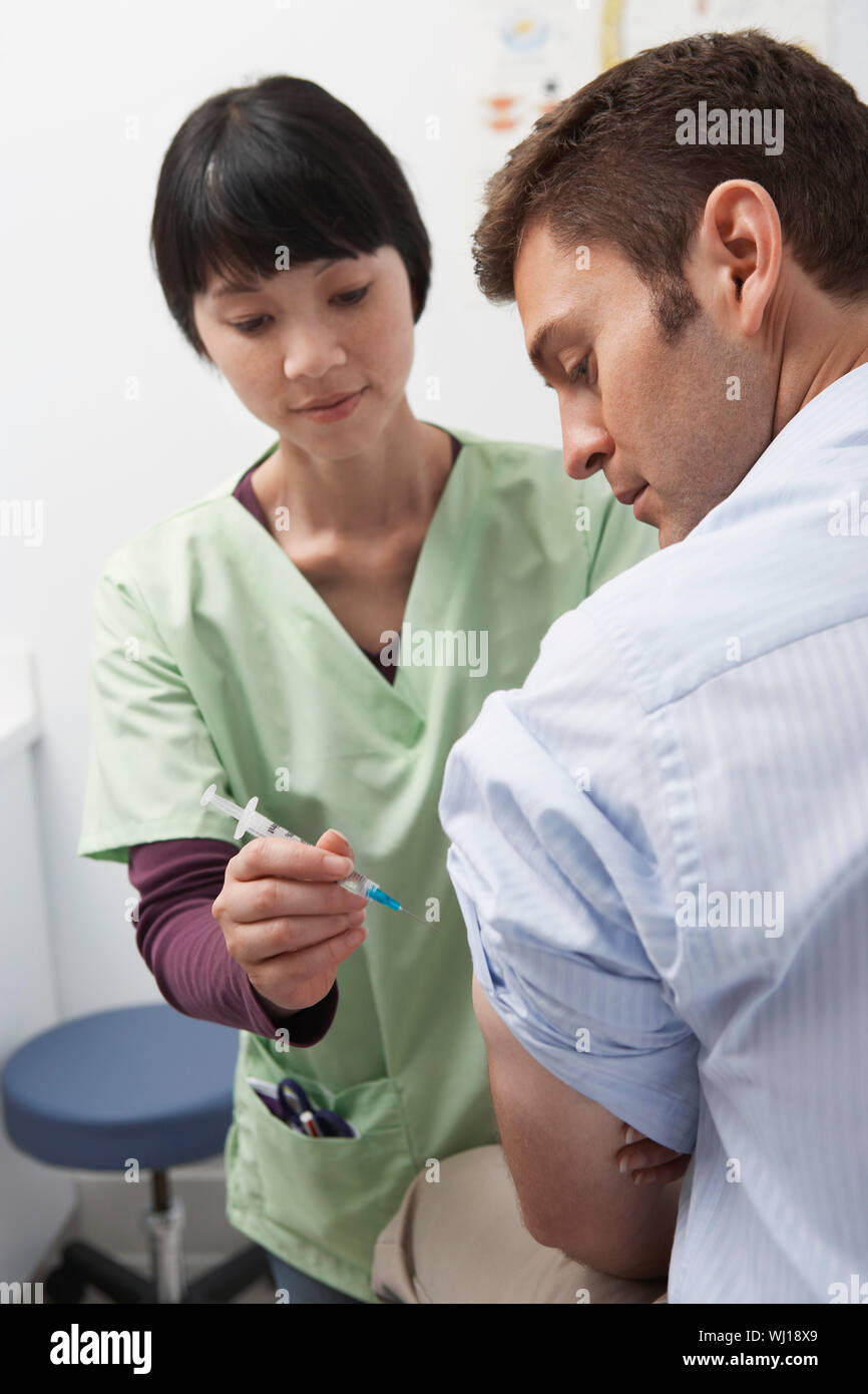 Doctor injecting male patient in hospital Stock Photo - Alamy