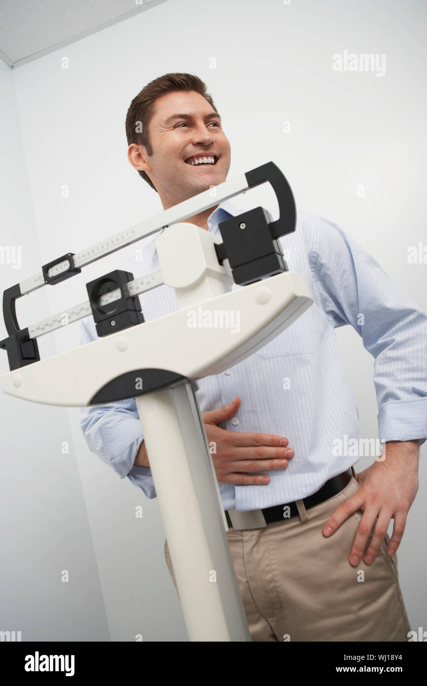 Man standing on weighing scales in hospital Stock Photo - Alamy