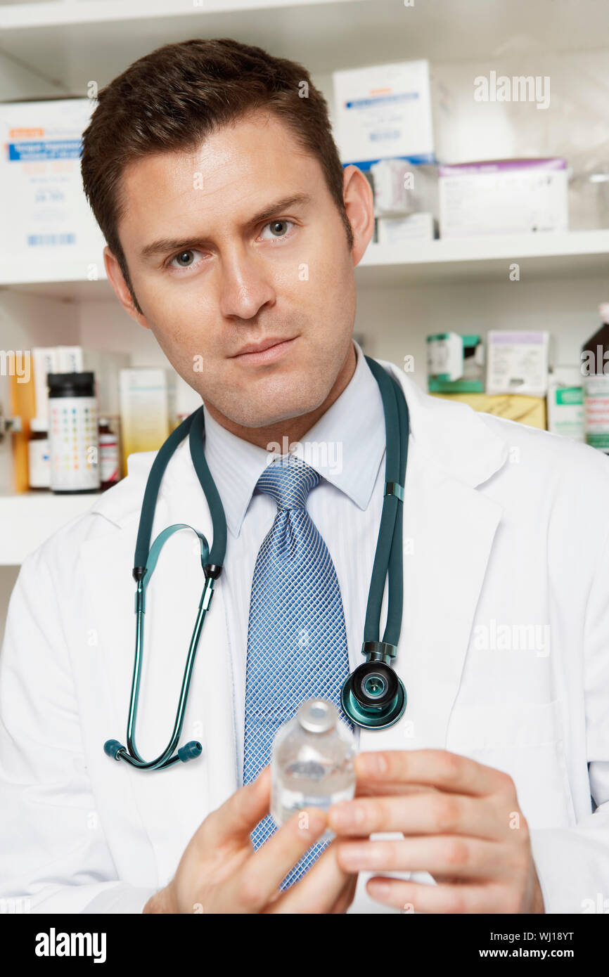 Male doctor holding medication bottle in hospital,portrait Stock Photo ...