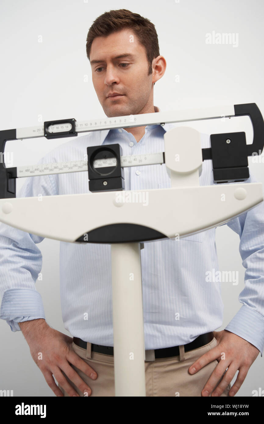 Man standing on weighing scales in hospital Stock Photo - Alamy