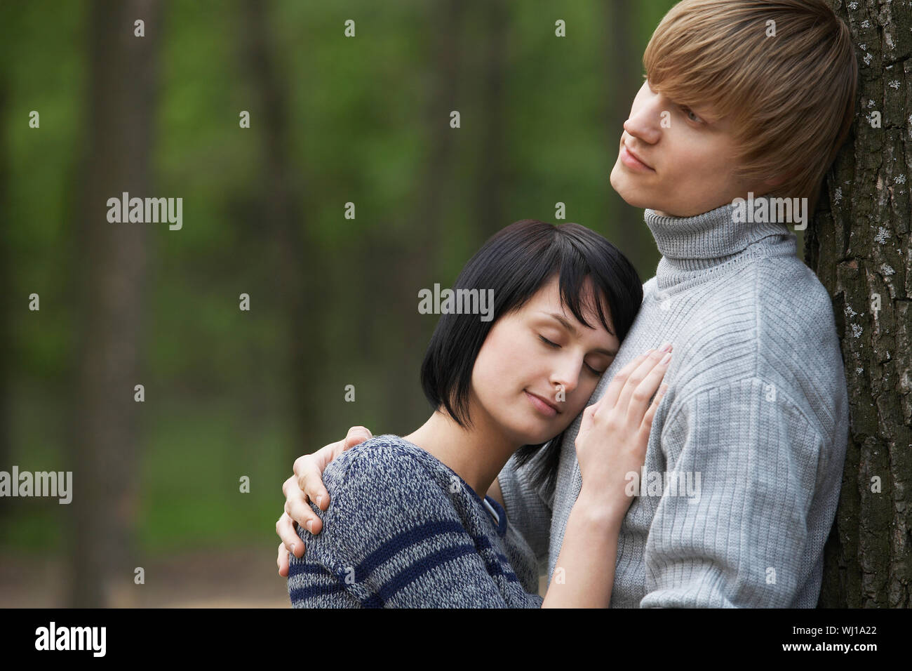 Side view of a young woman laying head on man's chest in woods Stock ...