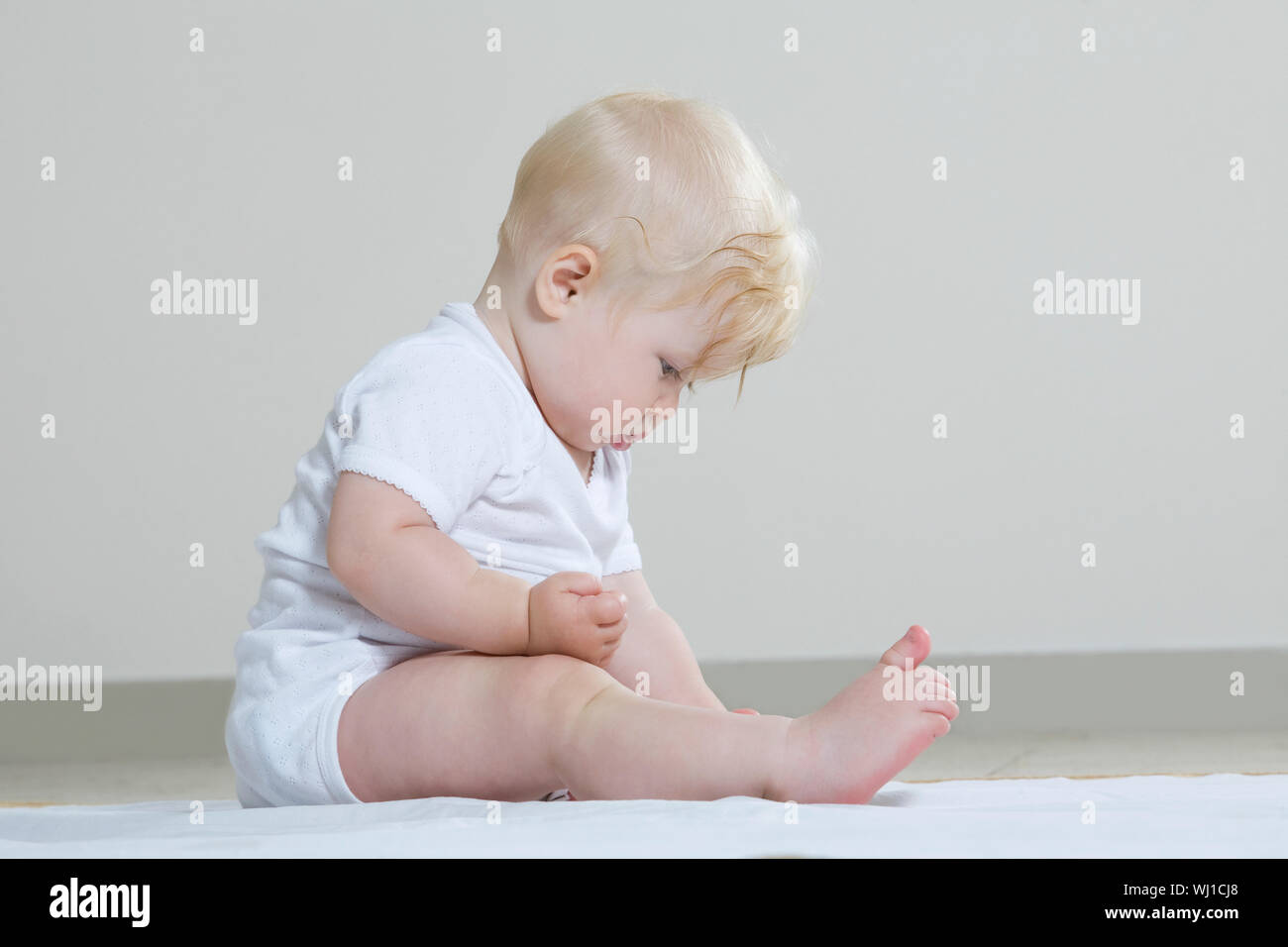 Full length side view of a baby girl playing on floor Stock Photo - Alamy