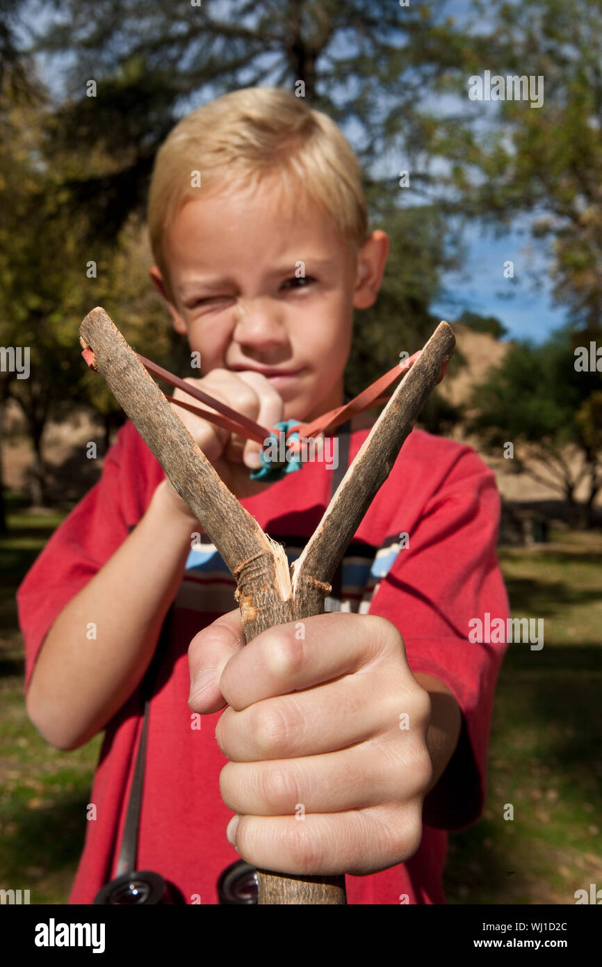 Closeup portrait of a blond boy using slingshot Stock Photo - Alamy