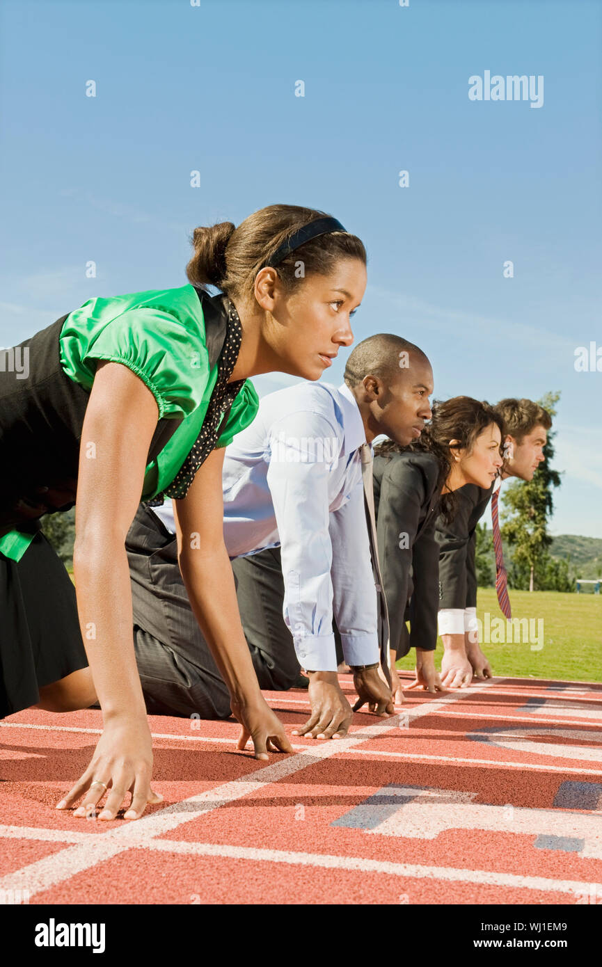 Side view of multiethnic business people at starting line on race track ...