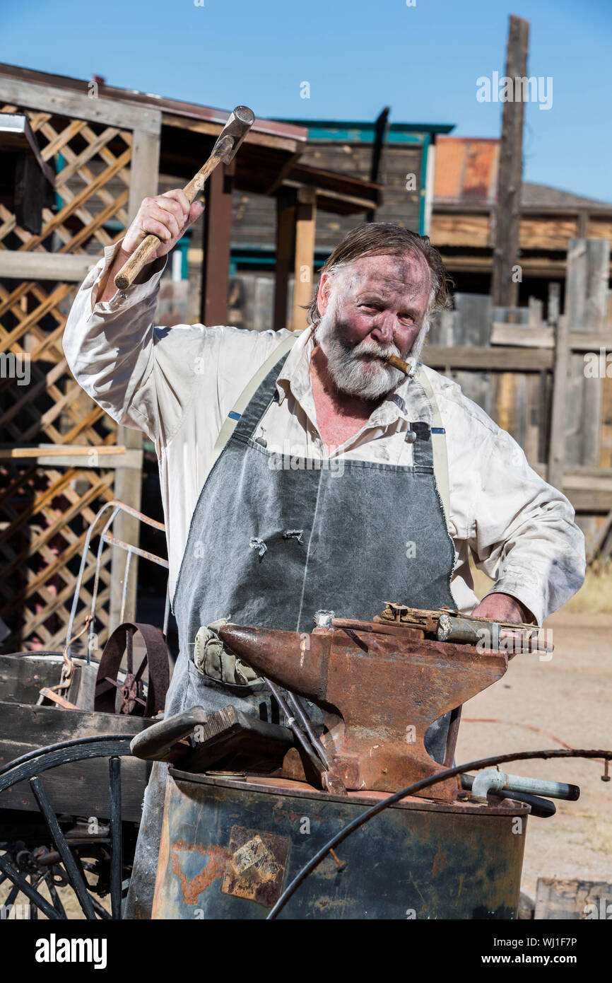 Old West Blacksmith Swings Hammer at an Anvil Stock Photo - Alamy